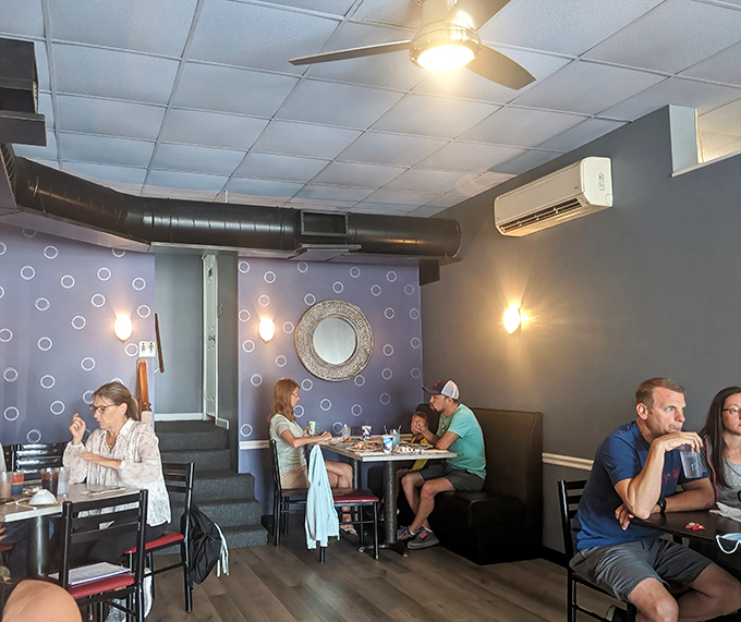 The purple accent wall and warm lighting create breakfast ambiance that says, "Stay awhile, your office can wait."