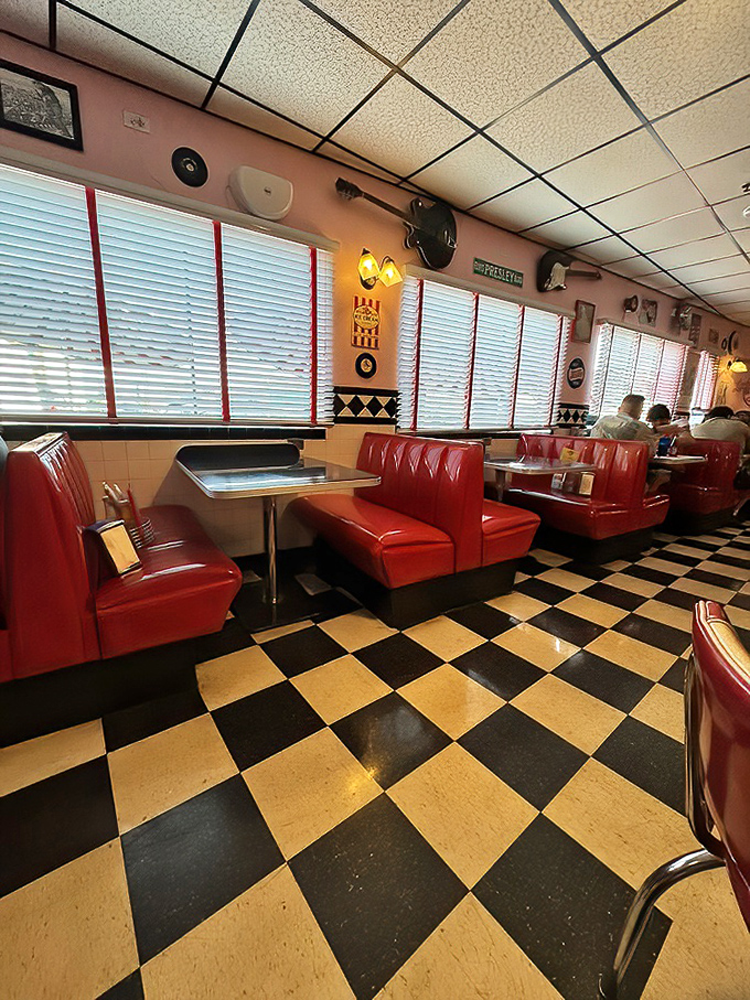 Red booths against checkerboard floors create the classic American diner tableau. Sliding into these seats feels like starring in your own '50s sitcom.