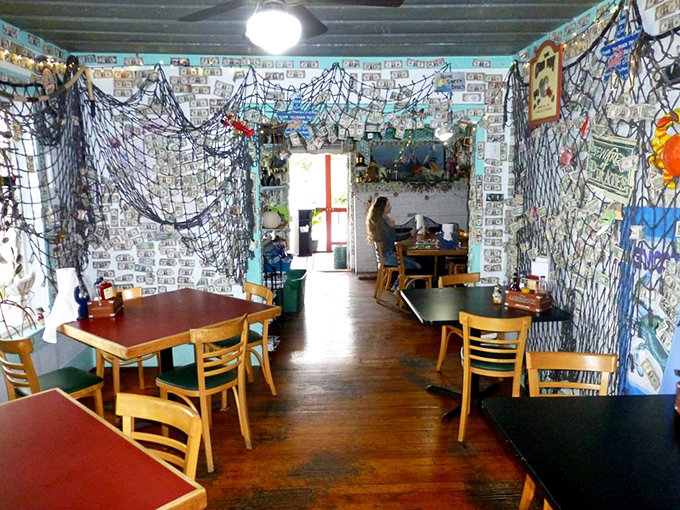 Fishing nets and dollar bills create a maritime museum vibe. The wooden floors have likely witnessed countless seafood celebrations over the years.