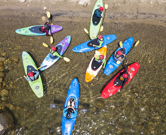 Colorful kayaks gather like a floating rainbow&mdash;a refreshing sight when you live in a town where "waterfront property" usually means "next to the sprinkler."