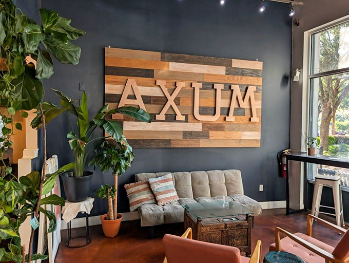 The lounge area where "I'll stay for five minutes" turns into two hours. Reclaimed wood, lush plants, and comfortable seating create the perfect hideaway.