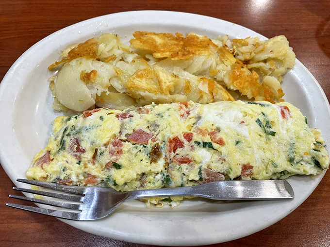 This omelet doesn't just contain ingredients; it tells a story of perfect morning harmony between eggs, potatoes, and whatever deliciousness is folded inside.