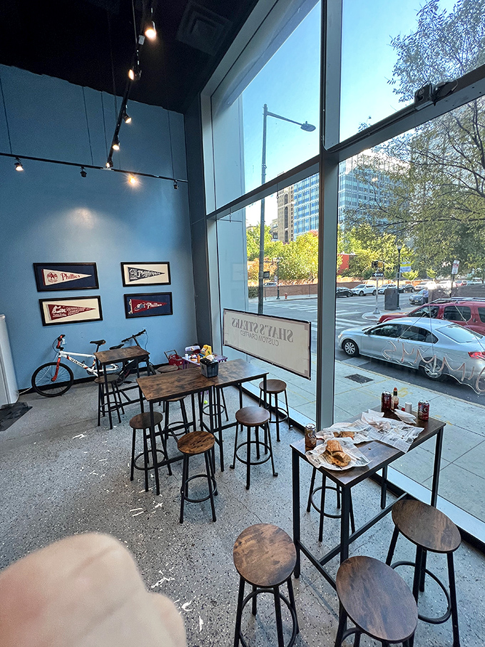 High ceilings, sports pennants, and tall windows create a space where time slows down just enough to savor every bite.