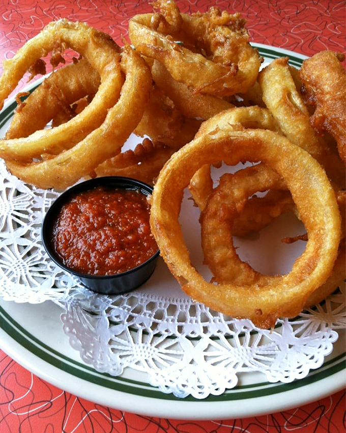Onion rings so perfectly golden they deserve their own trophy. That marinara sauce is standing by for dunking duty.