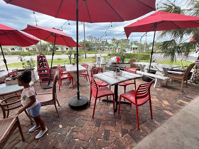 Outdoor dining under Naples' blue skies. Red umbrellas create islands of shade where breakfast dreams come true amid gentle Florida breezes.