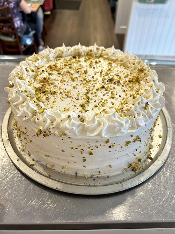 That pistachio cake isn't just dessert, it's architecture&mdash;layers of moist cake wearing a crown of whipped frosting and crushed nuts like edible confetti.