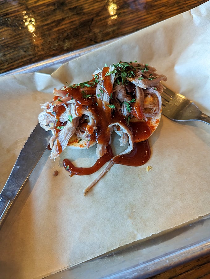 Pulled pork on an egg with sauce drizzled like modern art&mdash;proof that sometimes the simplest presentations deliver the most profound flavors.