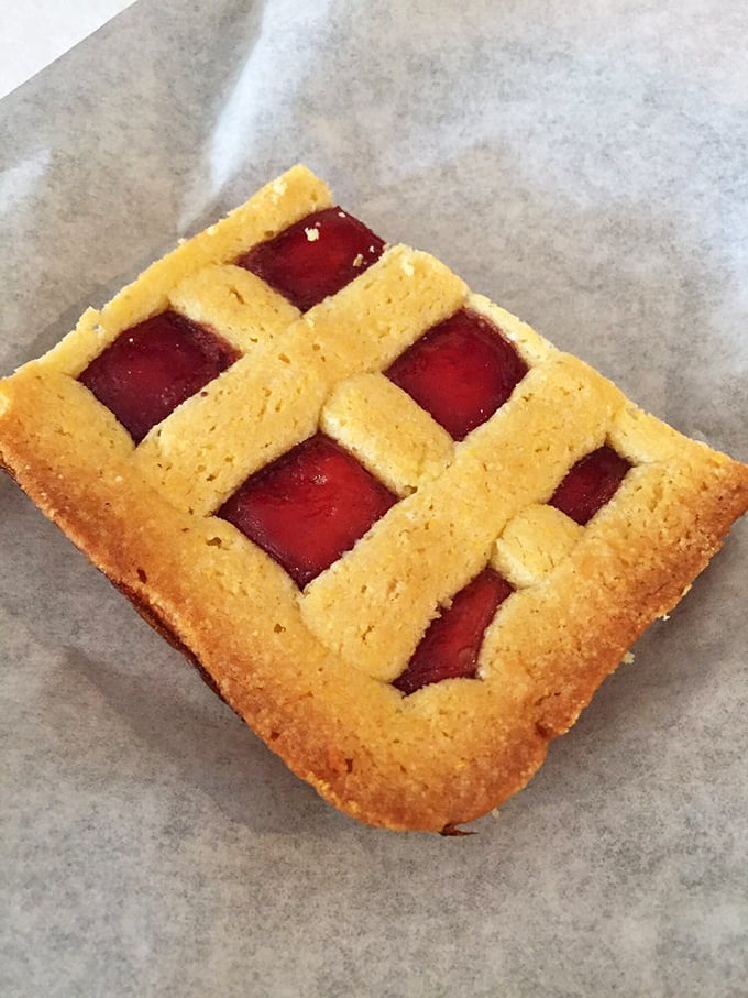 This raspberry square isn't just dessert &ndash; it's edible stained glass, a perfect balance of buttery crust and tangy fruit.