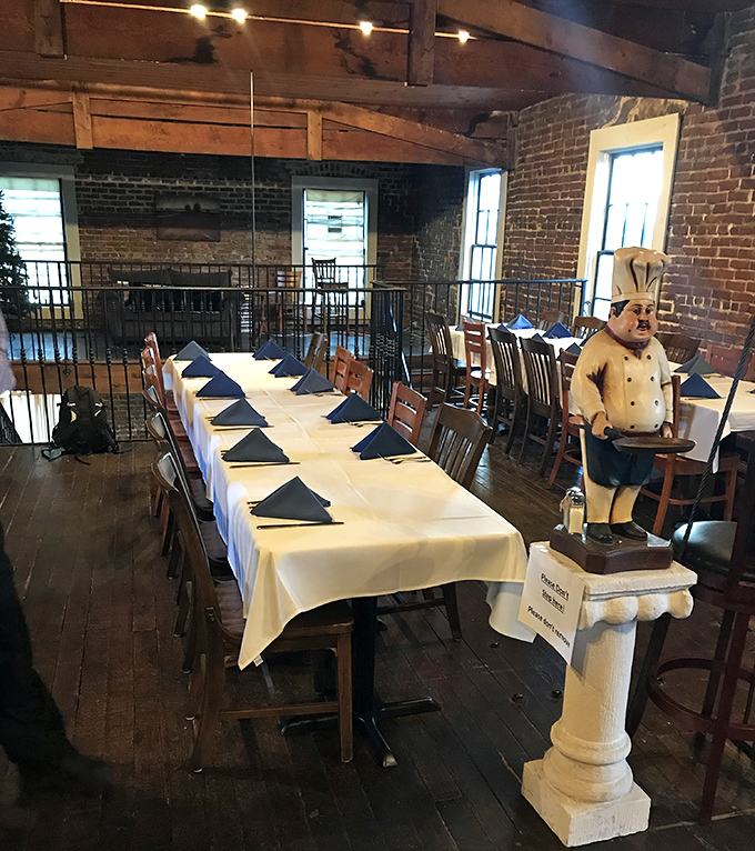 The private dining area stands ready for celebration, with the chef statue keeping watch like a culinary guardian angel over tables dressed in their finest whites.