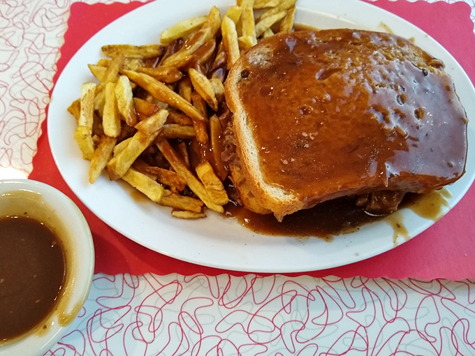 Gravy isn't just a topping here&mdash;it's a philosophical statement, creating a savory lagoon where your hot roast beef sandwich becomes an island paradise.