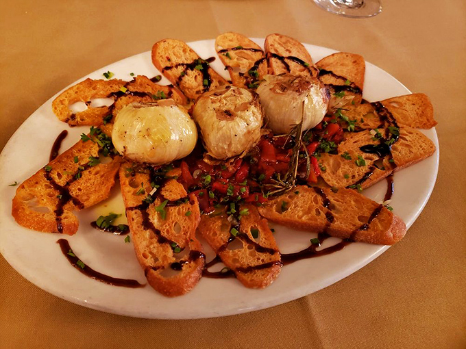 Roasted garlic and toast points arranged like a sunburst of flavor. The kind of appetizer that makes conversation pause mid-sentence.