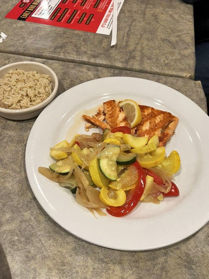 A seafood symphony on a plate&mdash;perfectly seared salmon alongside colorful saut&eacute;ed vegetables, proving Maryland does more than just crab well.
