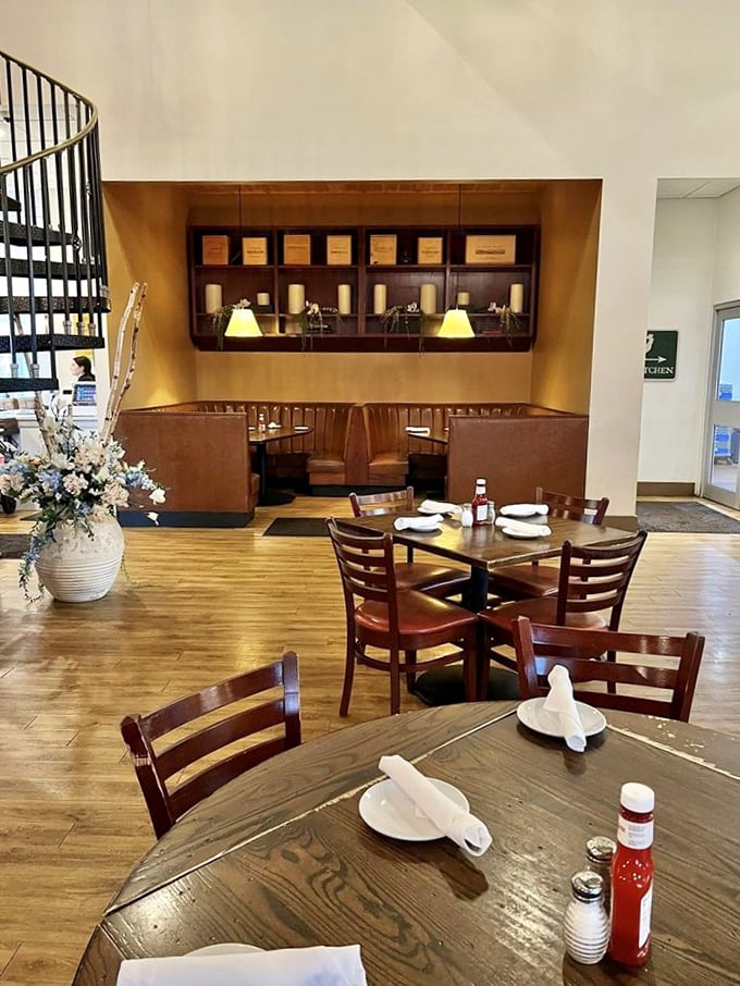 Leather booths and wooden tables create intimate dining nooks, while fresh flowers add touches of elegance to this sophisticated farmhouse setting.