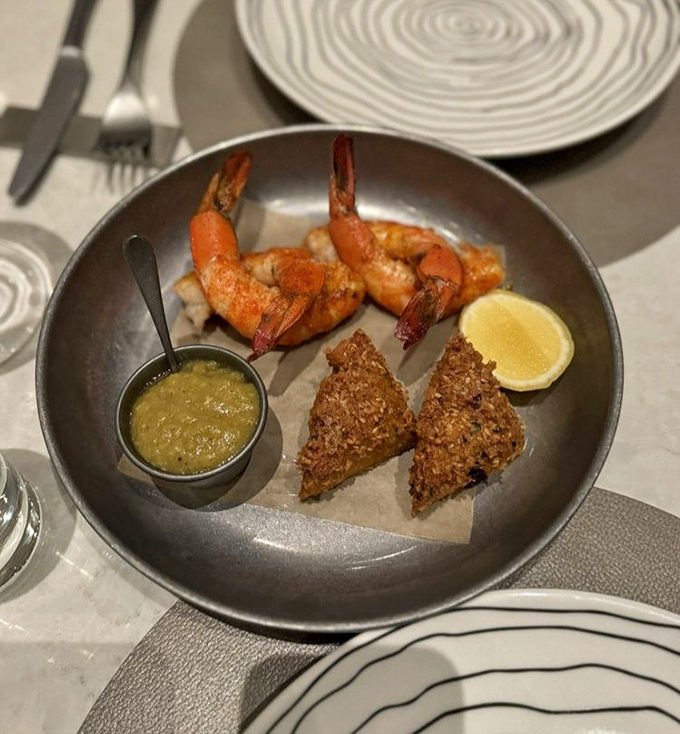 This isn't just shrimp on a plate&mdash;it's a masterclass in texture and flavor, with perfectly cooked shrimp and savory grits, all complemented by a vibrant green puree that makes the whole dish sing.