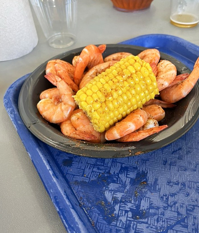 Steamed shrimp surrounding corn on the cob &ndash; a plate that says "vacation" more clearly than your out-of-office email ever could.