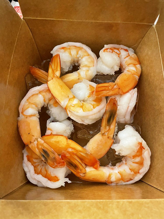 These shrimp aren't just cooked, they're arranged in their cardboard vessel like synchronized swimmers performing their final bow.