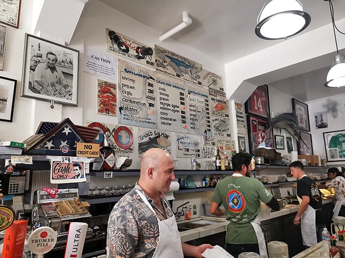 Behind the counter, seafood artisans in their element. These guys can shuck an oyster faster than most people can unlock their phones.