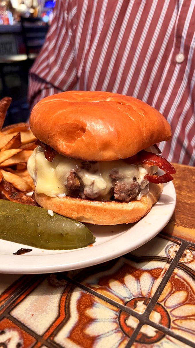 This burger isn't just food; it's a commitment. The pickle alongside looks like it's contemplating its life choices.