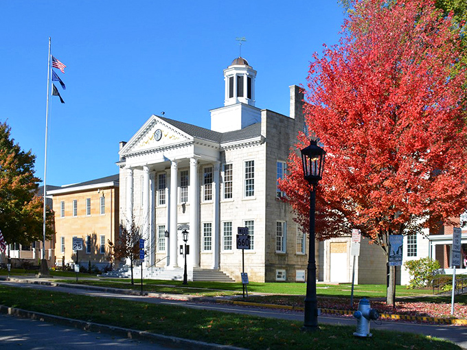 Tioga County Courthouse stands proud with its classical columns and cupola, especially striking against autumn's fiery maple trees. Small-town America at its most picturesque.
