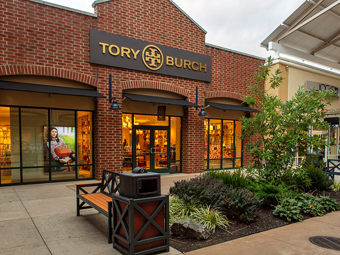 Tory Burch's brick-fronted boutique showcases luxury at less painful prices. The perfectly manicured landscaping hints at the refined bargains within.