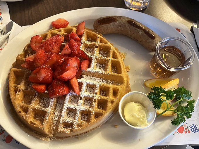 A waffle that's achieved the perfect golden-brown tan, topped with strawberries that look like they're having their own little party.