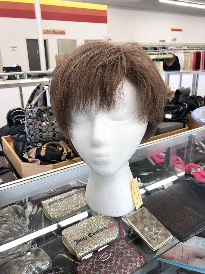 This wig isn't just hair&mdash;it's a personality waiting to happen, perched atop a mannequin head like a patient cat.