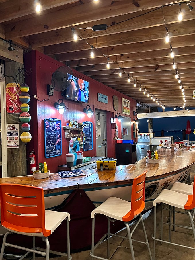A bar built from what looks like an old boat hull, where string lights twinkle overhead like stars guiding sailors home to their next pint.