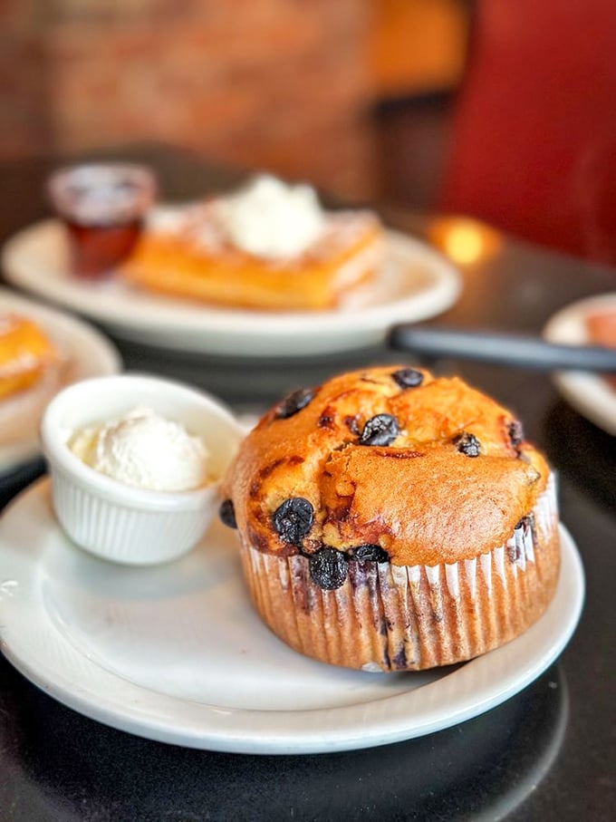 This blueberry muffin isn't just baked&mdash;it's architecturally designed for maximum berry distribution. The side of cream is just showing off.