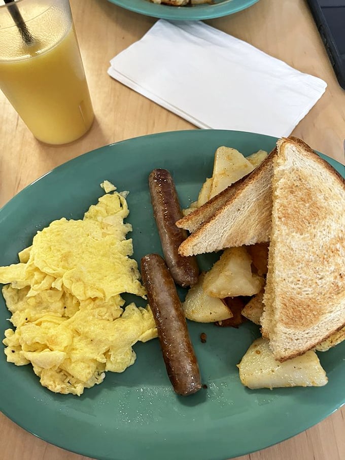The breakfast trinity&mdash;fluffy scrambled eggs, perfectly browned sausage links, and toast that's actually buttered to the edges. Simple perfection with home fries.