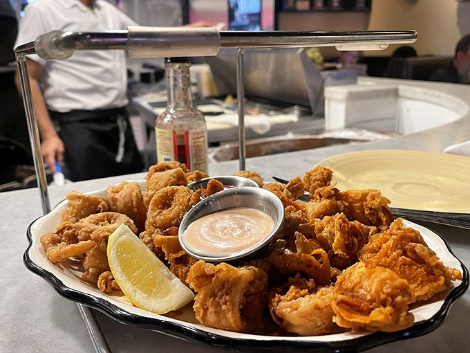 Golden, crispy calamari that shatters with each bite, served with a wedge of lemon that's practically begging to be squeezed. The ocean never tasted so good.