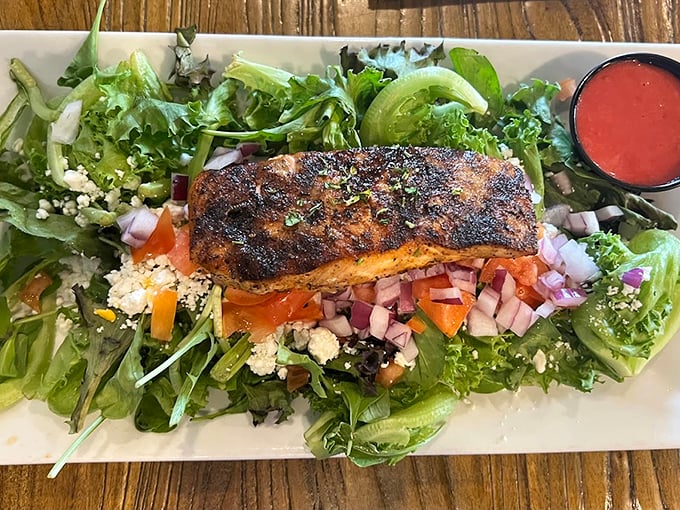A perfectly blackened piece of fish resting on a bed of greens &ndash; proof that healthy eating doesn't have to feel like punishment.