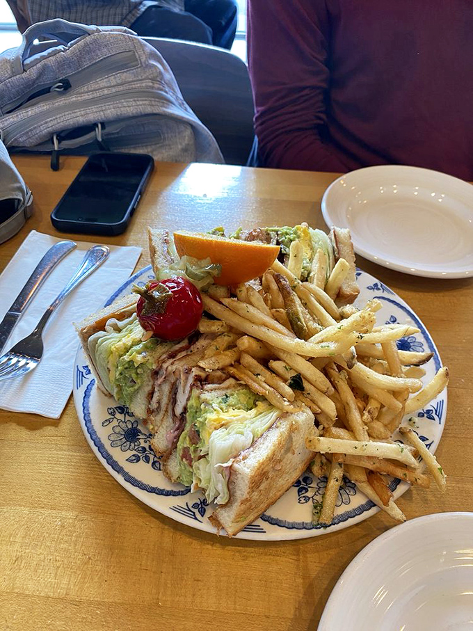 A club sandwich built like architectural marvel, proving that sometimes bigger really is infinitely better.