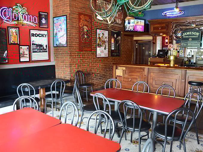 The bar area blends nostalgia and conviviality with exposed brick walls, vintage posters, and red tables that have hosted countless celebrations, first dates, and friendly debates.