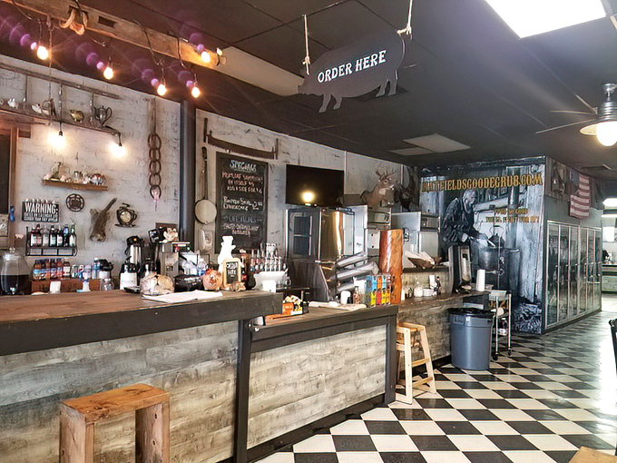 The "ORDER HERE" sign dangles above barbecue nirvana. String lights add warmth, but it's those sauce bottles standing at attention that tell the real story.