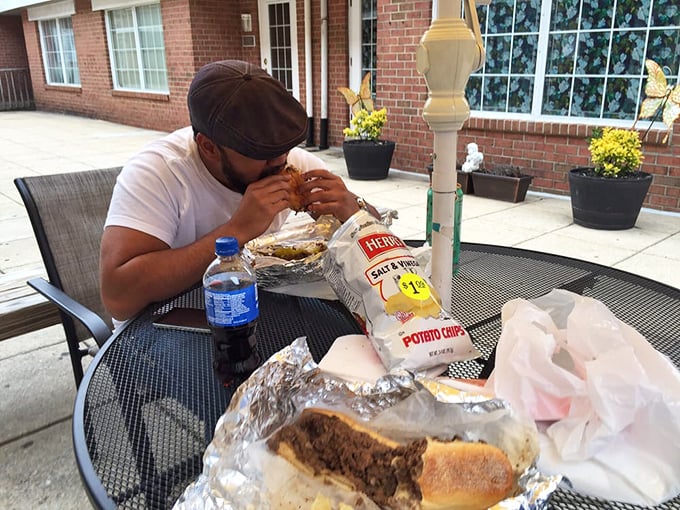 The outdoor dining experience: one man, one magnificent sandwich, and the kind of focus usually reserved for neurosurgeons and chess grandmasters.