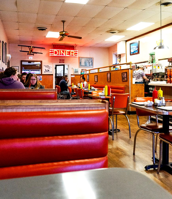 The neon "DINER" sign glows like a beacon for hungry souls. These booths have heard first dates, business deals, and family celebrations for decades.
