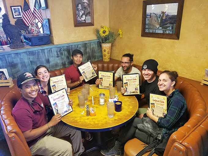 Happy diners showing off their menus like winning lottery tickets&mdash;the universal expression of "we found the good place."