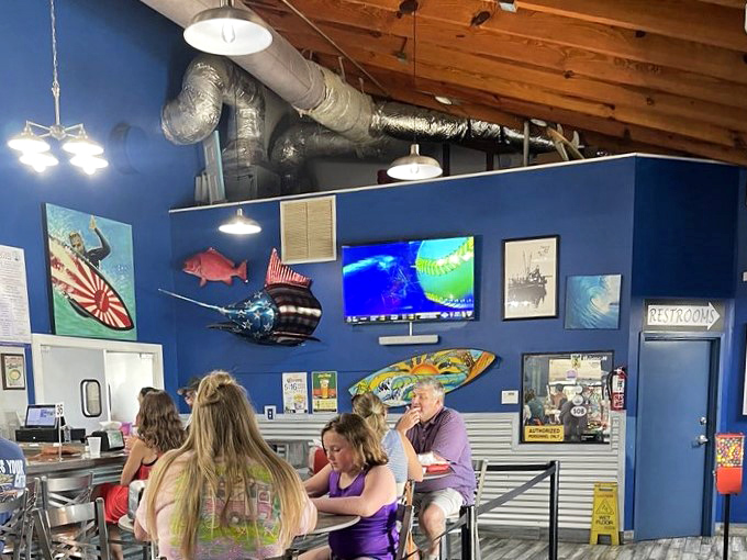 The vibrant blue walls adorned with maritime treasures create the perfect backdrop for seafood storytelling. Where fishing tales get taller with each satisfied bite.