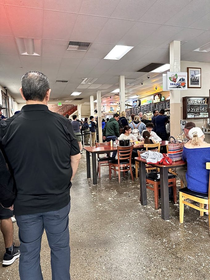The sawdust-covered floor crunches underfoot as diners queue up, a charming anachronism in our sanitized modern world.