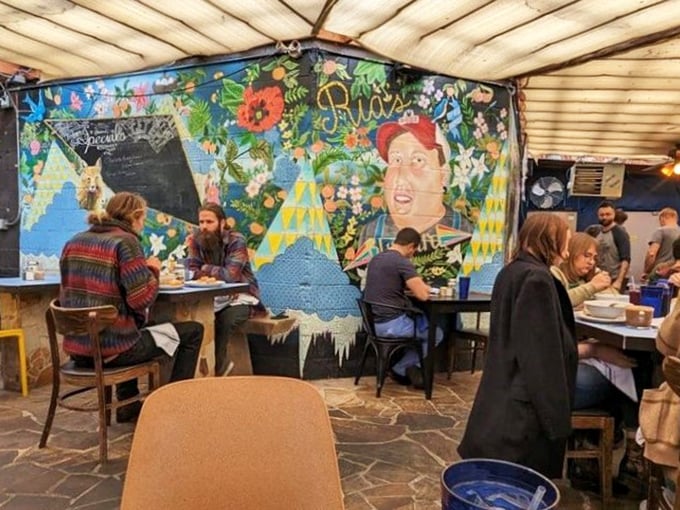 The covered patio feels like dining in an artistic friend's backyard. That mural isn't just decoration&mdash;it's a conversation starter between bites