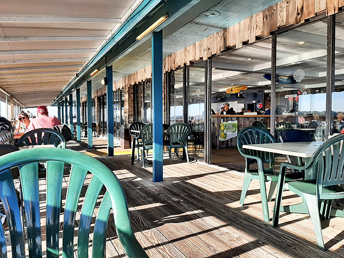 The weathered deck has seen countless sunsets and happy diners. These plastic chairs have hosted more memorable conversations than most five-star restaurants.