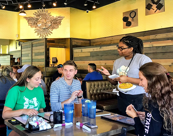 The server delivers golden-hued happiness while diners contemplate the age-old question: one more waffle or real-world responsibilities?