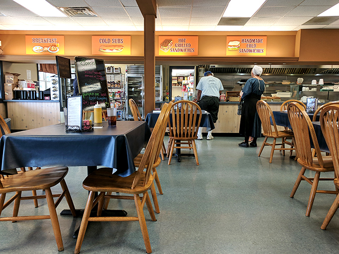 Where magic happens. The open kitchen design lets you witness the choreography of comfort food creation while wooden chairs invite you to stay awhile.