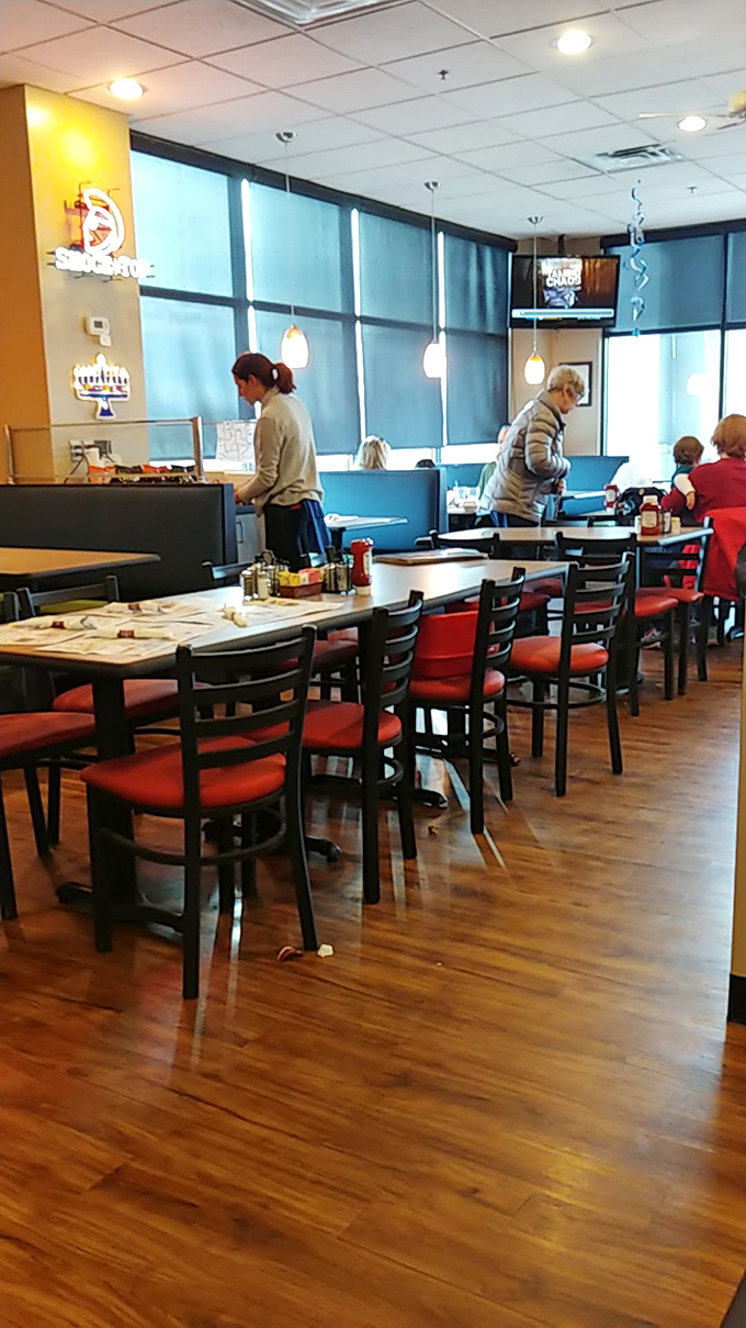 Red chairs pop against wooden floors in a dining room where strangers become friends, united by the universal language of "mmmmm."