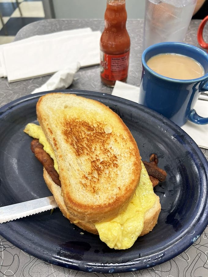The breakfast sandwich that launched a thousand napkins &ndash; crispy toast, fluffy eggs, and what appears to be bacon creating the morning's perfect trinity.