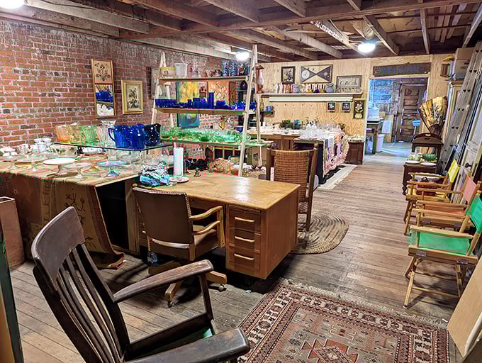 Exposed brick walls and wooden beams frame this dealer's space where vintage desks and colorful glassware create a perfectly imperfect tableau. 