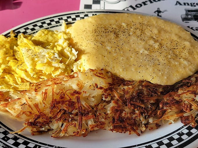 The holy trinity of breakfast perfection: crispy hash browns with edges that shatter like glass, fluffy scrambled eggs, and a pancake the size of your childhood dreams.