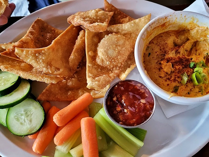 Hummus so smooth it could negotiate peace treaties, accompanied by fresh vegetables for guilt-free indulgence.