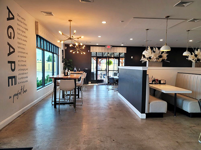 The wall proudly spells out "AGAPE" while modern lighting fixtures create an atmosphere that's both trendy and timeless. Concrete floors never looked so inviting.