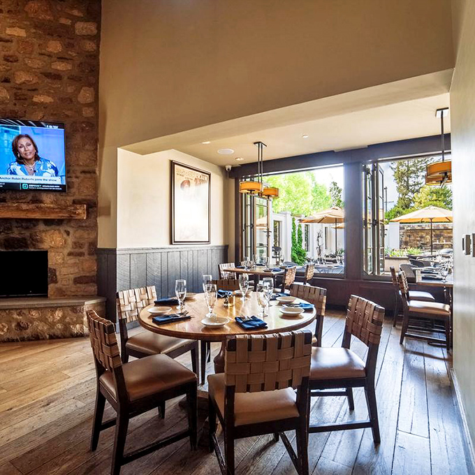 Stone walls meet modern design in this dining space where history and comfort coexist. Those folding doors to the patio? Pure genius.